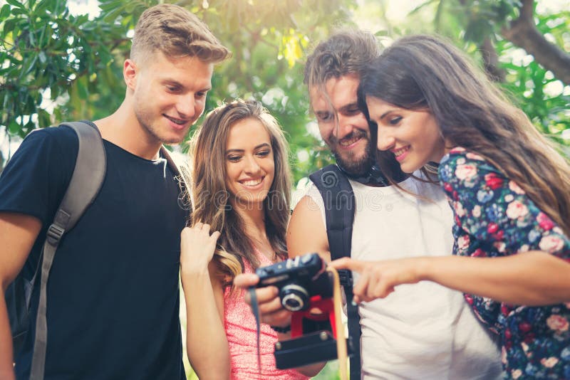 Friends or Couples Having Fun with Photo Camera in Park Stock Photo ...