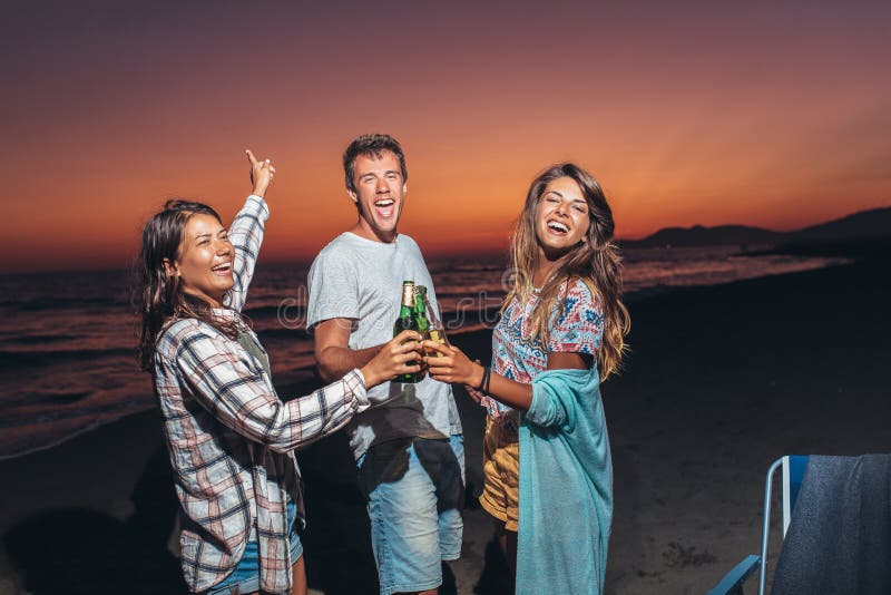 Friends Having Fun on the Beach Under Sunset Sunlight. Stock Photo ...