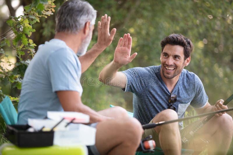 Friends Giving High Five while Fishing Stock Photo - Image of unity ...