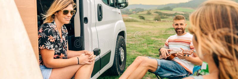 Friends Having Fun Talking and Playing Ukulele in Front of Their Camper ...