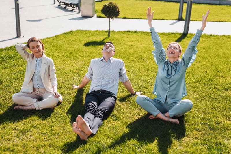 Friends Having a Rest Sitting on Grass in Sun Rays Stock Photo - Image ...