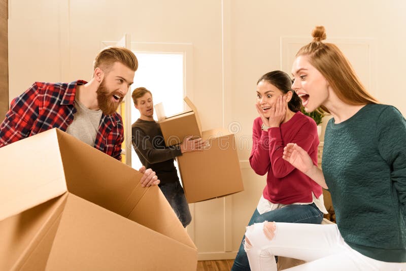 Friends Holding Cardboard Boxes at New Home Stock Image - Image of ...