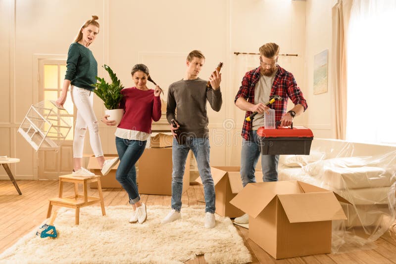 Friends Holding Different Things for Moving into New House Stock Photo ...