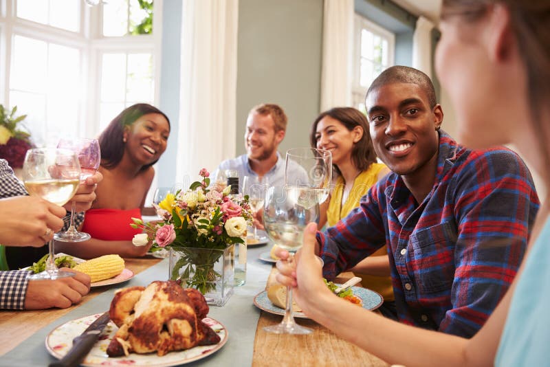Friends at Home Sitting Around Table for Dinner Party Stock Photo ...