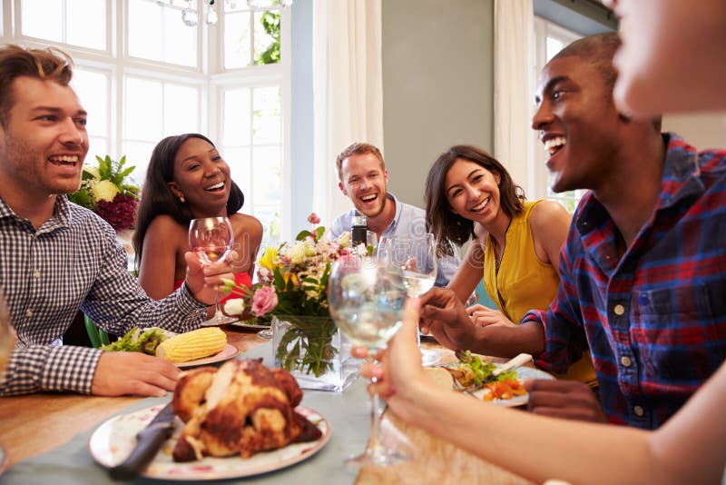 Friends at Home Sitting Around Table for Dinner Party Stock Image ...