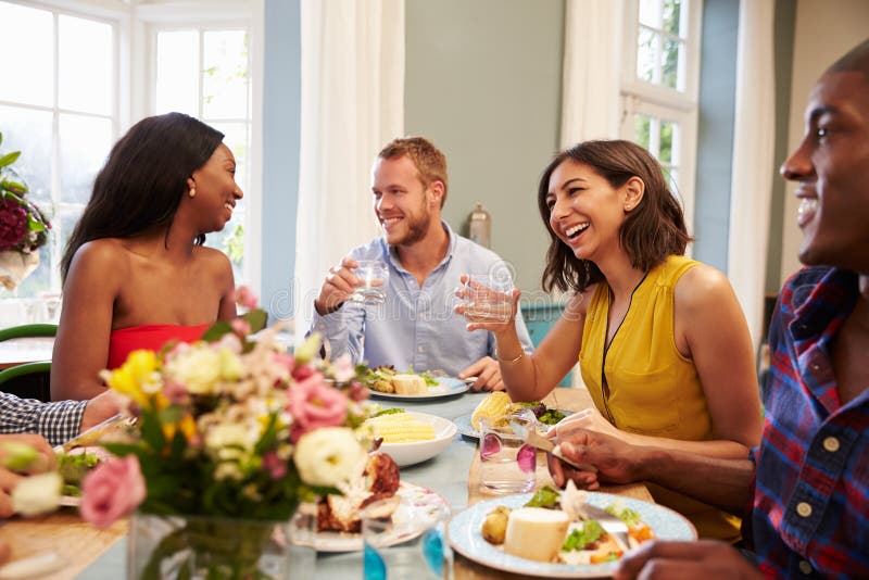 Friends at Home Sitting Around Table for Dinner Party Stock Photo ...