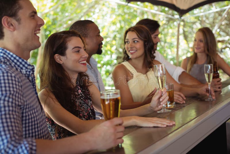 Friends Interacting while Having a Alcohol at Counter Stock Image ...