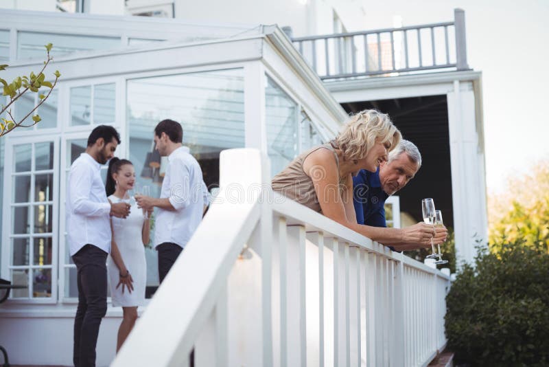 Friends Interacting while Having Champagne in Balcony Stock Image ...