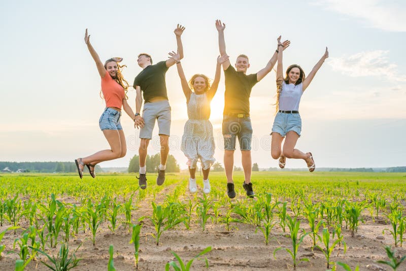 Friends are Jumping Holding Hands at Sunset. Stock Image - Image of ...