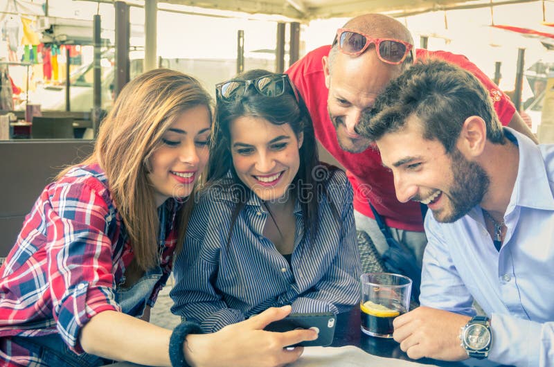 Friends Looking at Mobile Phone in a Bar Stock Photo - Image of ...