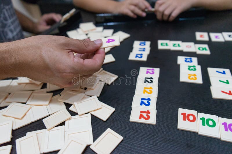 Friends Playing To a Strategy Game Board on a Table. Blocks of Number ...