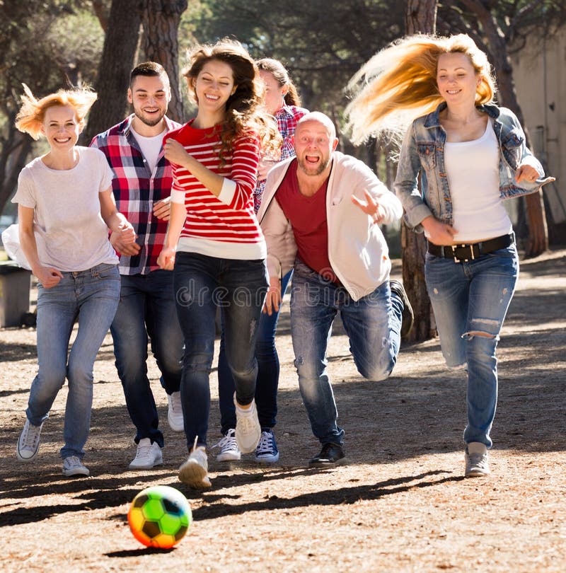 Friends running with ball stock image. Image of company - 53888947