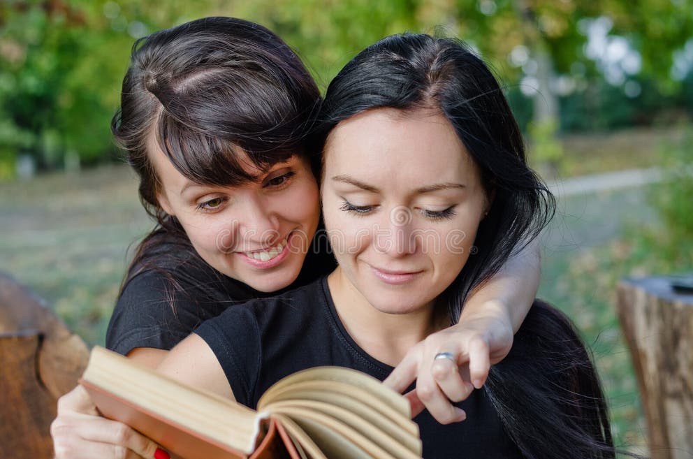 Friends sharing a book stock image. Image of outdoors - 29448201