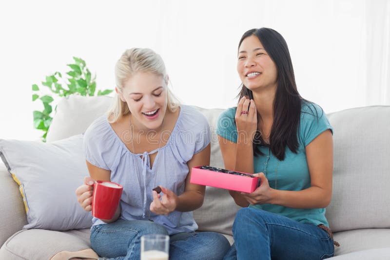 Friends Sharing a Box of Chocolates and Laughing Stock Photo - Image of ...