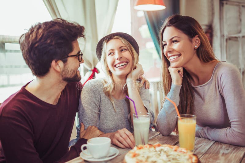 Friends Sharing Pizza in a Indoor Cafe Stock Image - Image of food ...