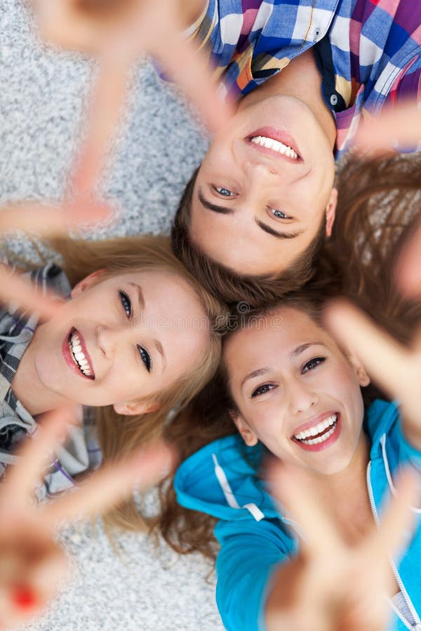 Friends showing peace sign stock photo. Image of lying - 26743616