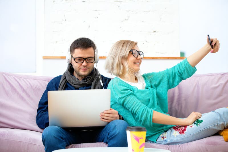 Friends Sit on the Couch, Chatting and Using a Smartphone, Desktop ...