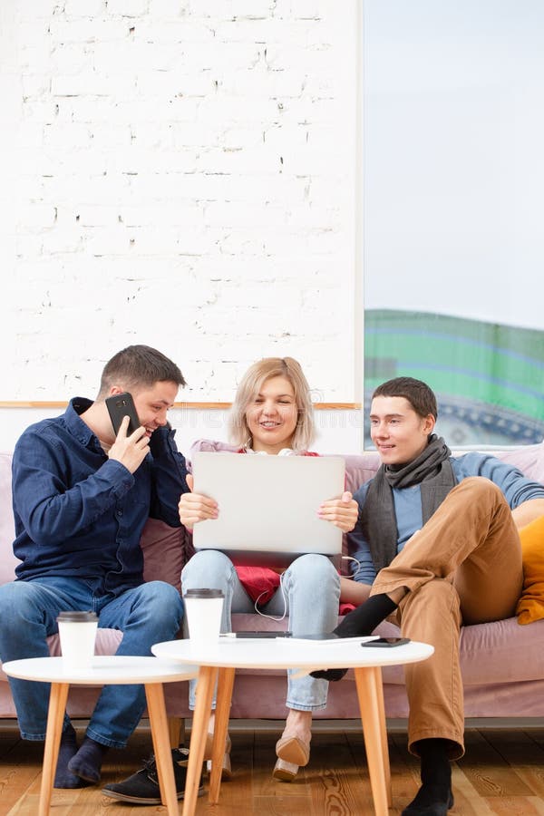 Friends Sit on the Couch, Chatting and Using a Smartphone, Desktop ...