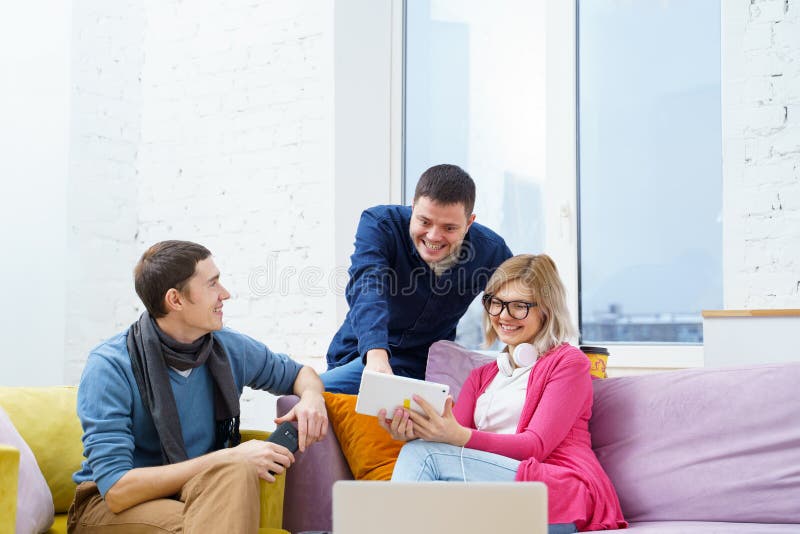 Friends Sit on the Couch, Chatting and Using a Smartphone, Desktop ...