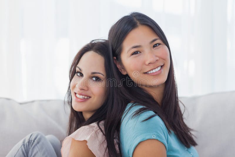 Friends Sitting Back To Back Smiling at Camera Stock Image - Image of ...
