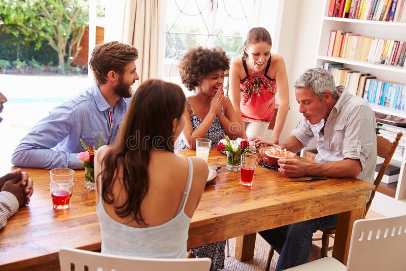 Friends Sitting at a Dining Table Celebrating a Birthday Stock Photo ...