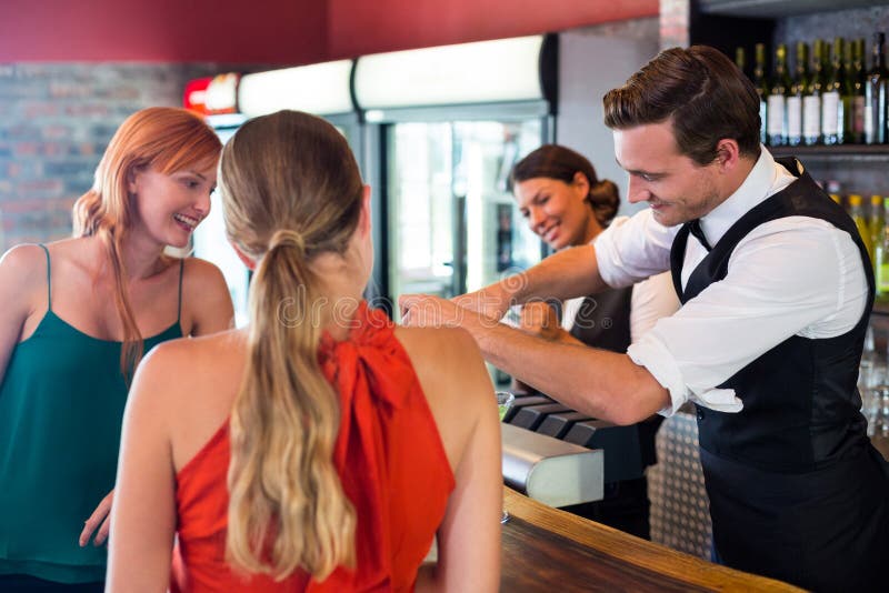Friends Standing at Counter while Bartender Preparing a Drink Stock ...