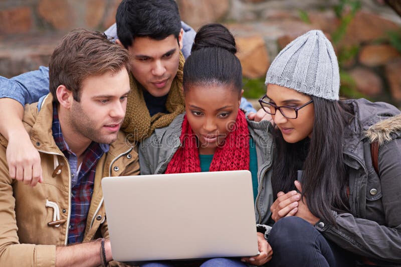 Friends and Study Partners. Shot of a Group of College Students Using a ...