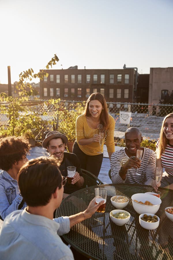 Friends Talking at a Party on a Rooftop, Vertical Stock Photo - Image ...