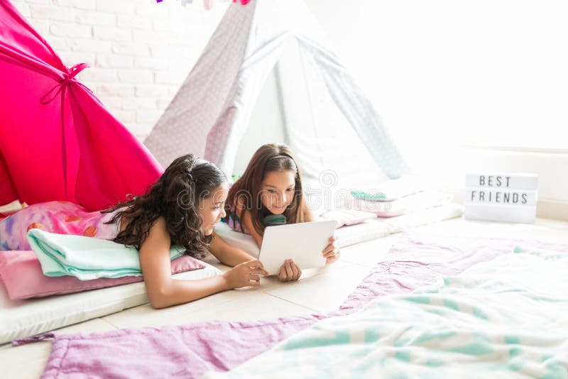 Friends Using Internet on Tablet Computer while Resting in Teepee Stock ...