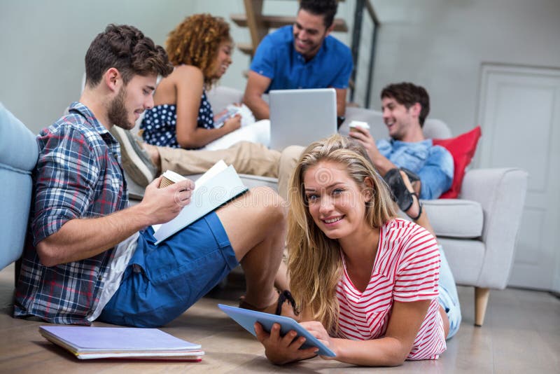 Friends Using Technologies while Relaxing in Living Room Stock Photo ...