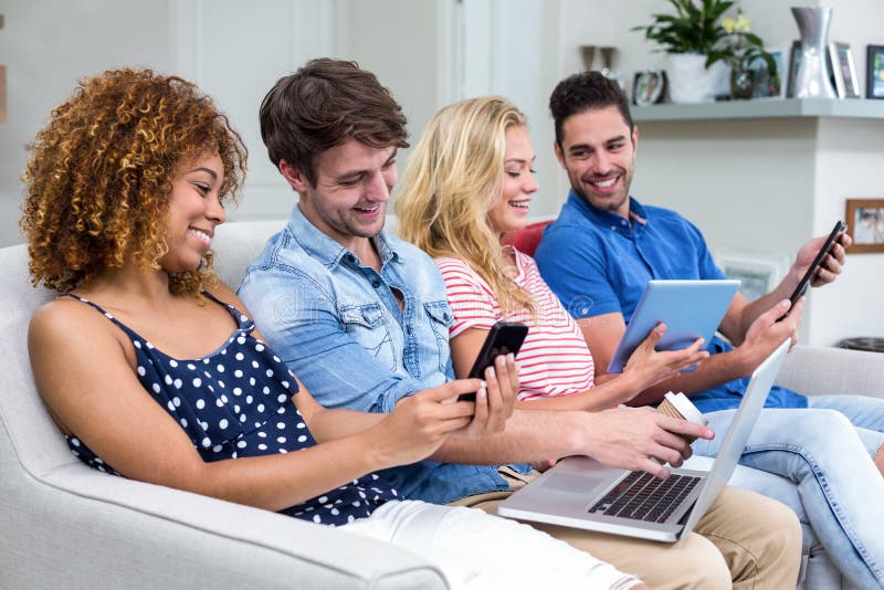 Friends Using Technologies on Sofa Stock Image - Image of female ...