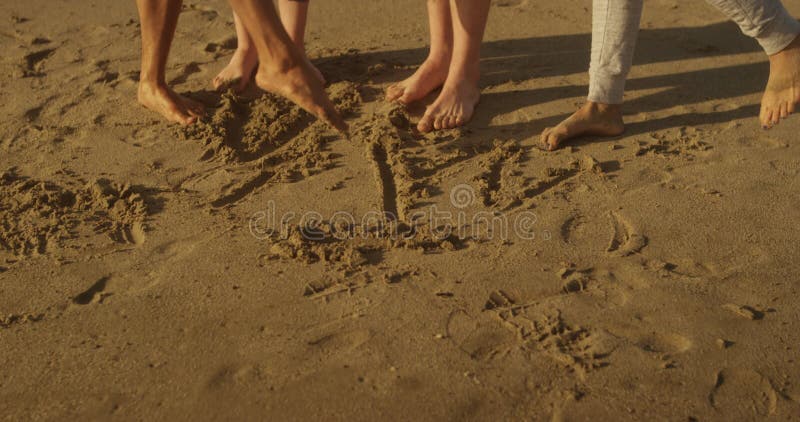 Friends Using Their Feet To Write on the Beach Stock Video - Video of ...