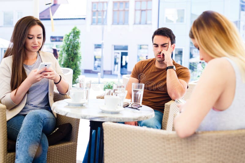 Friends Using Their Mobile Phones and Ignoring Each Other while Sitting ...