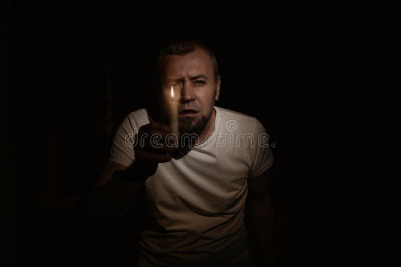 Frightened Man with a Candle during Blackout. Man Looking at the Camera ...