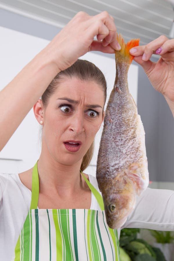 Frightened Woman Cooking Fish in the Kitchen Stock Photo - Image of ...