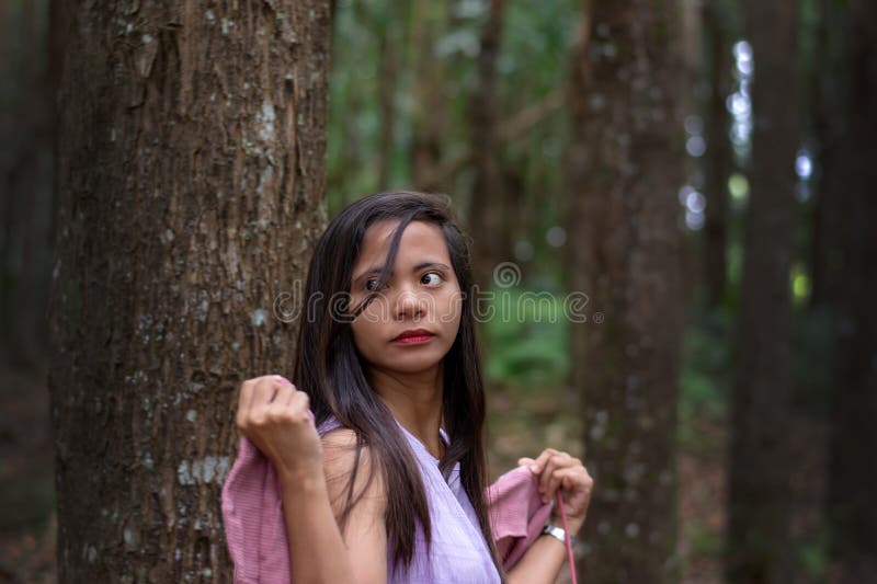 Frightened Young Woman Hiding Behind a Tree in the Forest from Danger ...