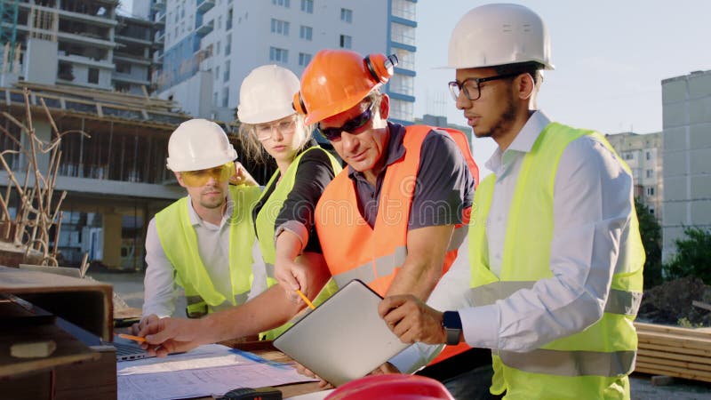 Diverse Group of Construction Workers Collaborate on a Construction ...