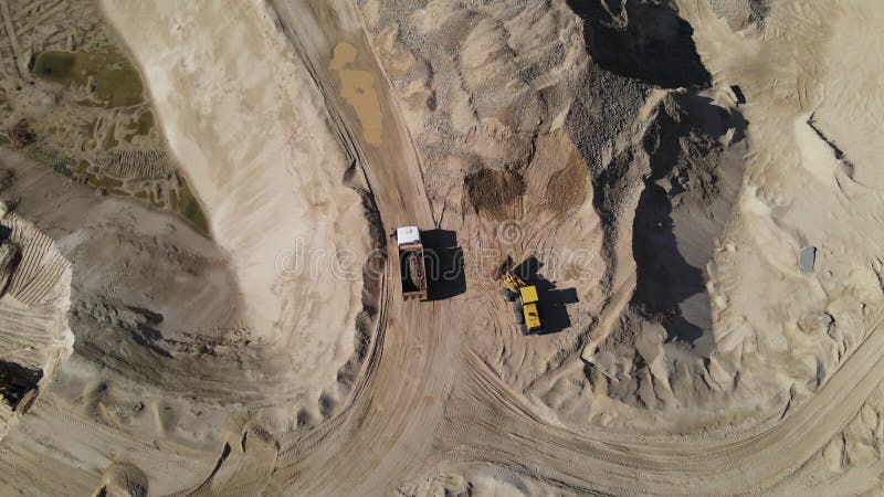 Front End Loader Loading Sand into Dump Truck in Open Pit Mine. Wheel ...
