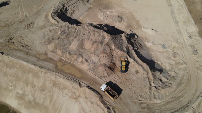 Front End Loader Loading Sand into Dump Truck in Open Pit Mine. Wheel ...