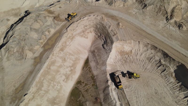 Front End Loader Loading Sand into Dump Truck in Open Pit Mine. Wheel ...