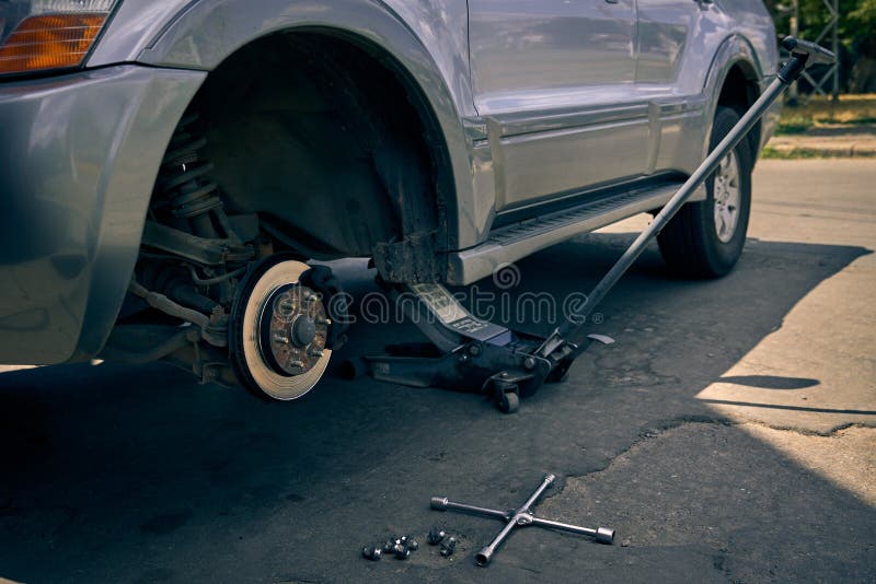 The Front Left Wheel is Dismantled from a Car Which is Propped Up on a ...