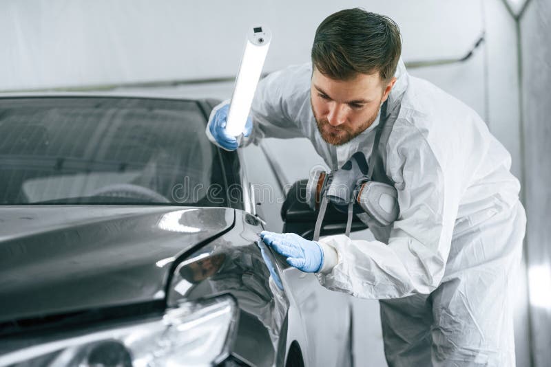 Front Part of the Automobile. Garage Worker is Holding Lighting and ...