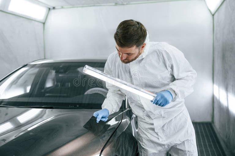 Front Part of the Automobile. Garage Worker is Holding Lighting and ...