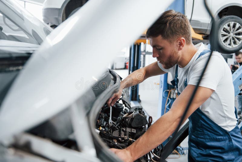 Front Part of the Car. Employee in the Blue Colored Uniform Works in ...