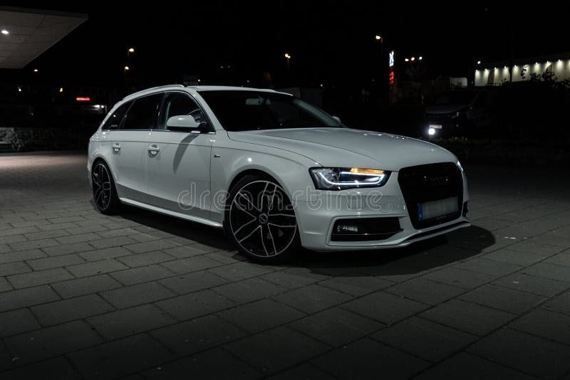 Front Part of White Audi A4 Avant with Lit Headlights Outdoors at Night ...