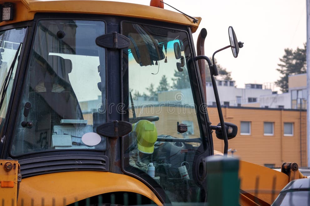 .the Front Part of a Yellow Excavator with a Cab in Which an Operator ...