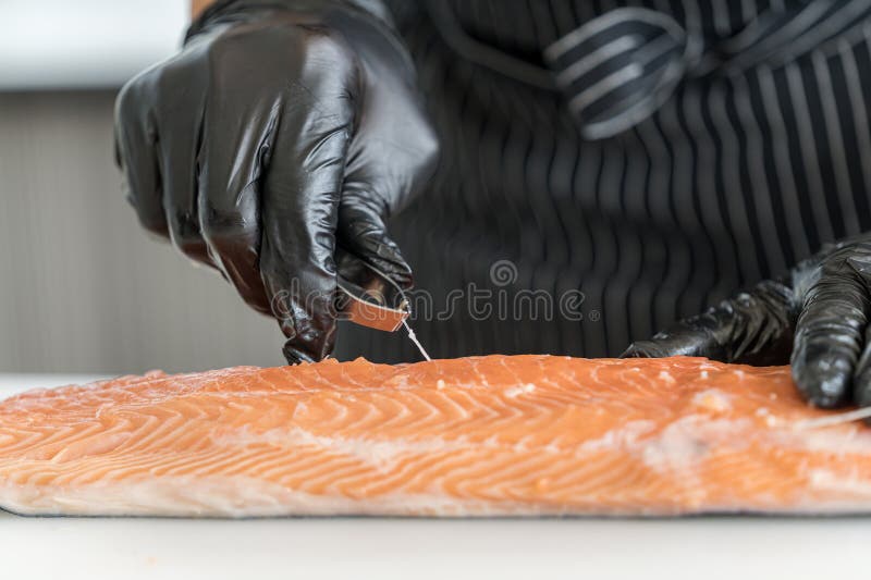 The Front of the Table. Close Up Hand of Chef Pulling Salmon Fish Bone ...