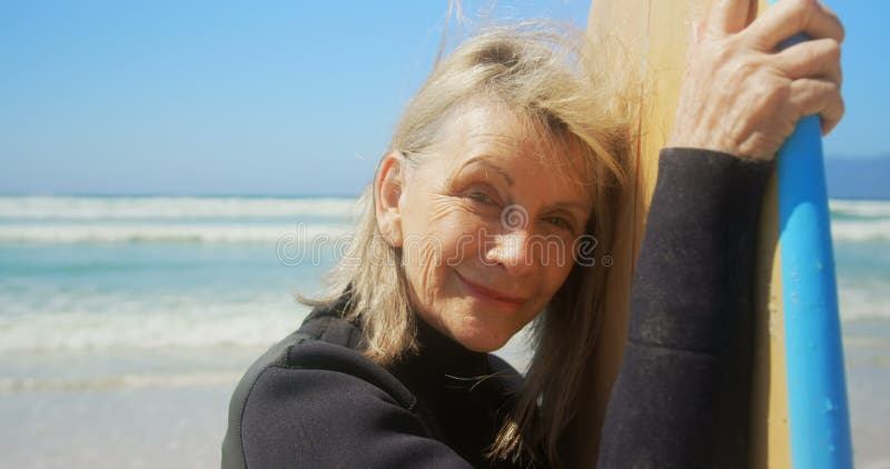 Front View of Active Senior Caucasian Female Surfer Standing with ...