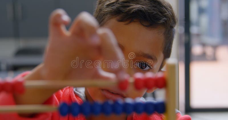 Front View of Asian Schoolboy Solving Math Problem with Abacus at Desk ...