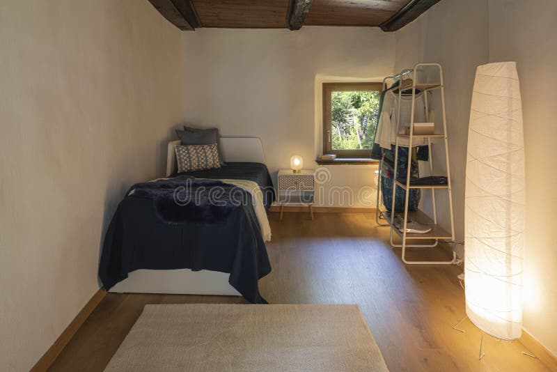 Front View Bedroom with Single Bed, Bedside Table with a Lamp Above and ...